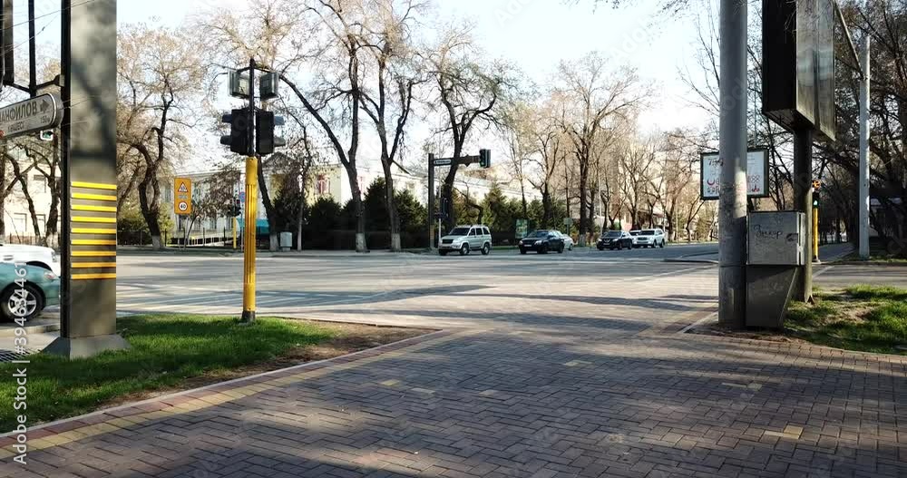 A city intersection with little traffic. The traffic light switches and ...