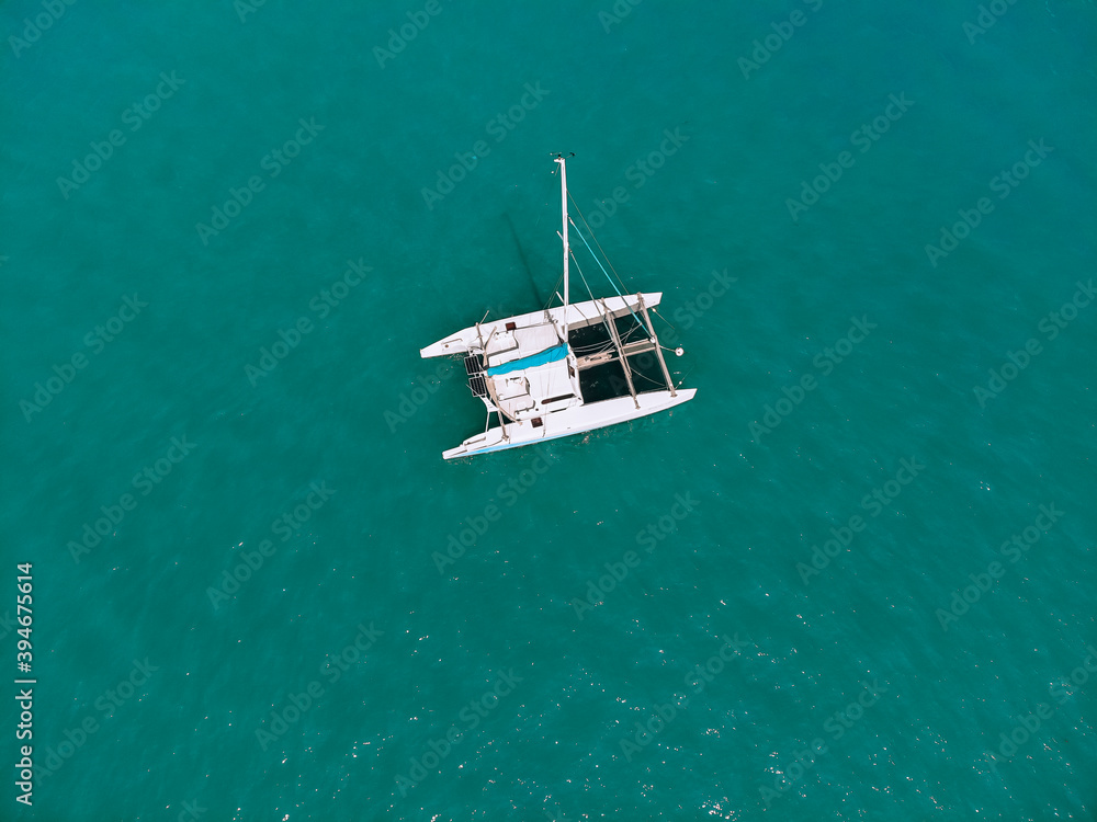 Bird's eyes view of the amazing white catamaran sailing across the blue ...