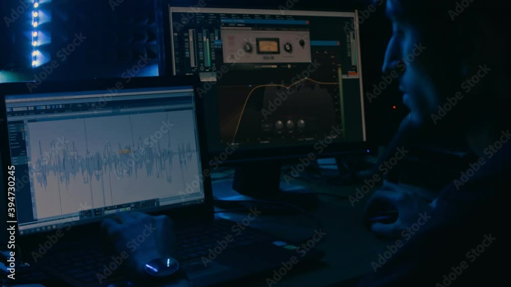 Recording studio. Profile of engineer working at the computer monitor ...