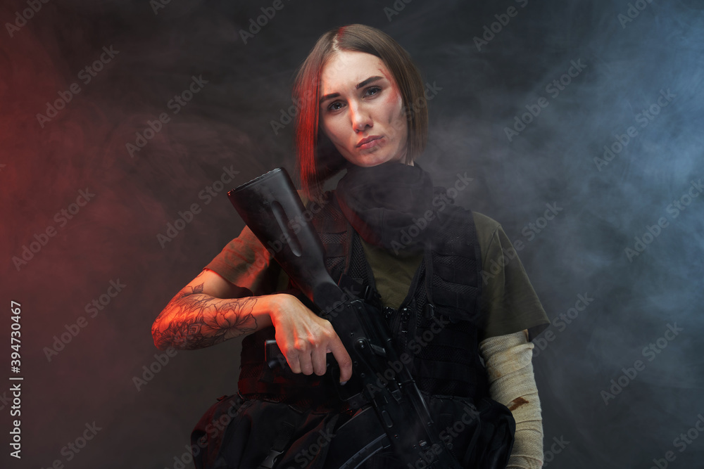 Tattooed beautiful female soldier in black armour with short haircut ...