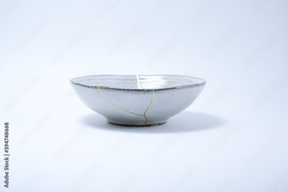 Kintsugi Japanese grey bowl. Gold cracks restoration on pottery ...