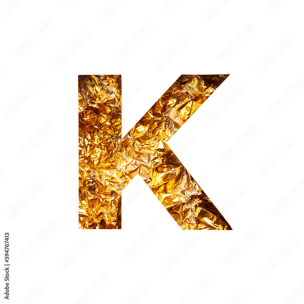 Gold letter K of English alphabet of shiny crumpled foil and paper cut ...