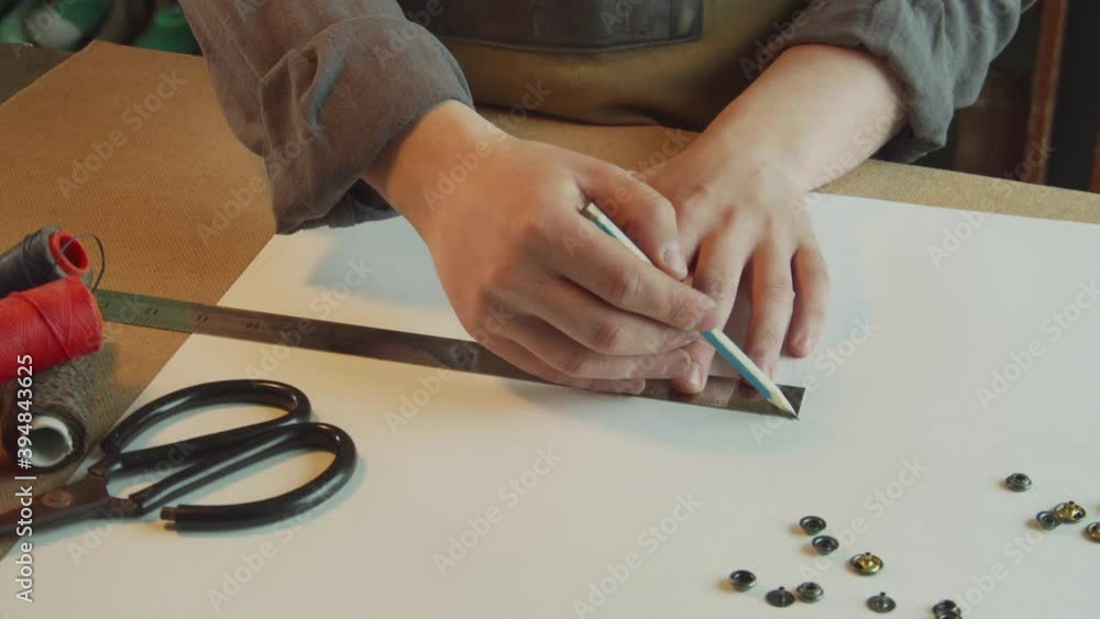 Top view the hands of a master shoemaker make a pencil drawing of the ...