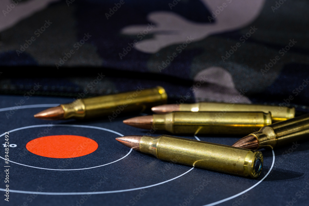 Loose rounds of rifle ammunition scattered on top of a paper target ...