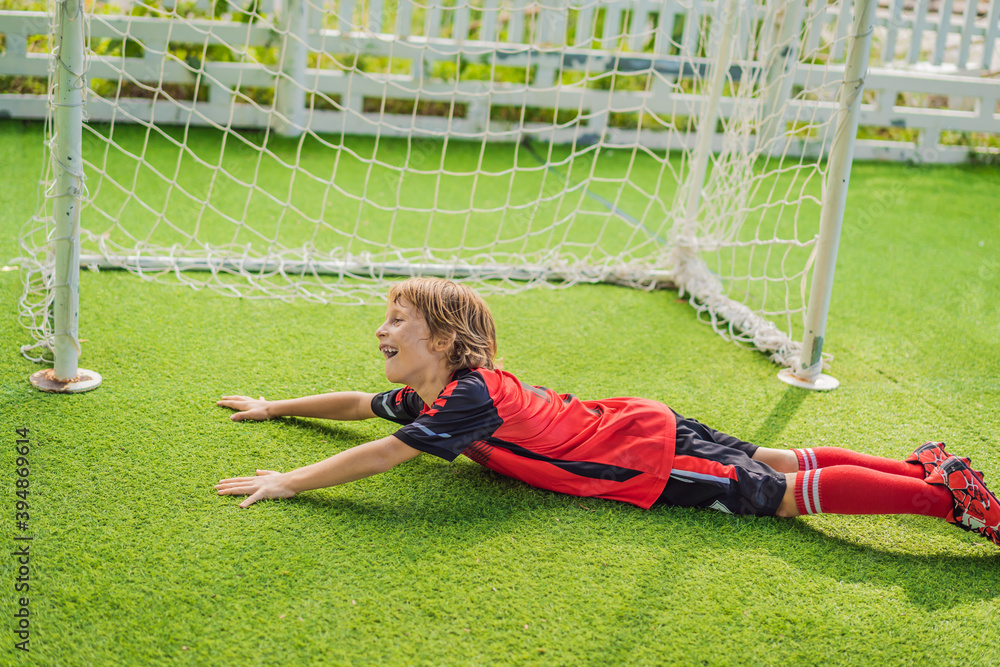 Little cute kid boy in red football uniform playing soccer, football on ...