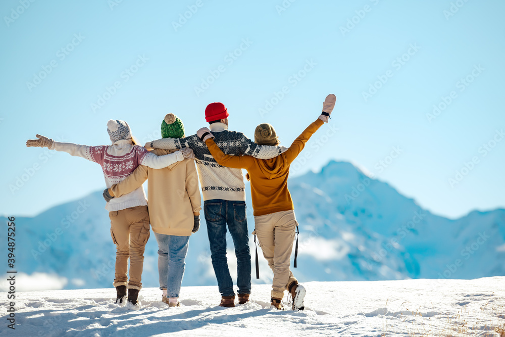 Happy friends embracing against snow capped mountains Stock Photo ...