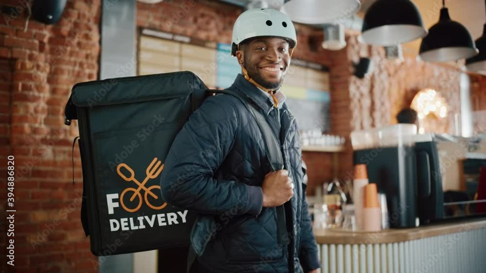 Handsome Black African American Food Delivery Courier Posing in Front of the Camera in a Coffee ...