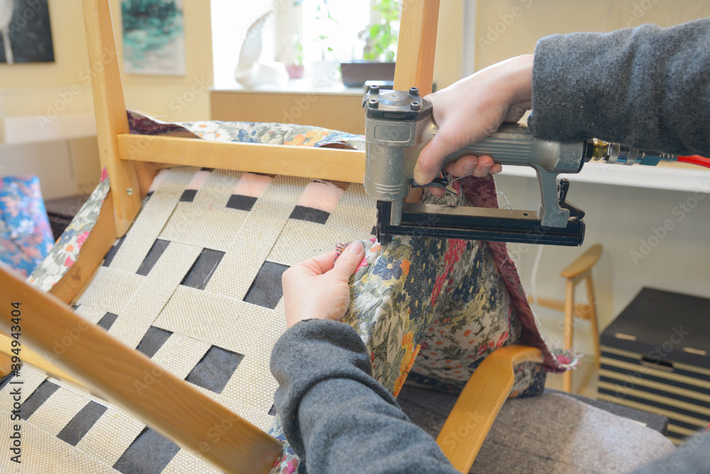 Making new upholstery on old chair. Woman hands working in upholstery ...