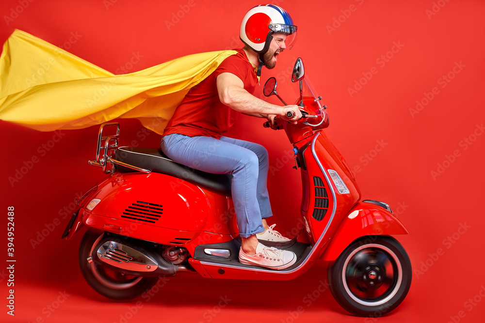 overjoyed mad crazy man driving moped fast speed wearing super hero ...