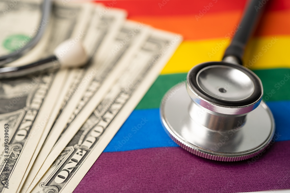 Black stethoscope and US dollar banknotes money on rainbow flag, symbol ...
