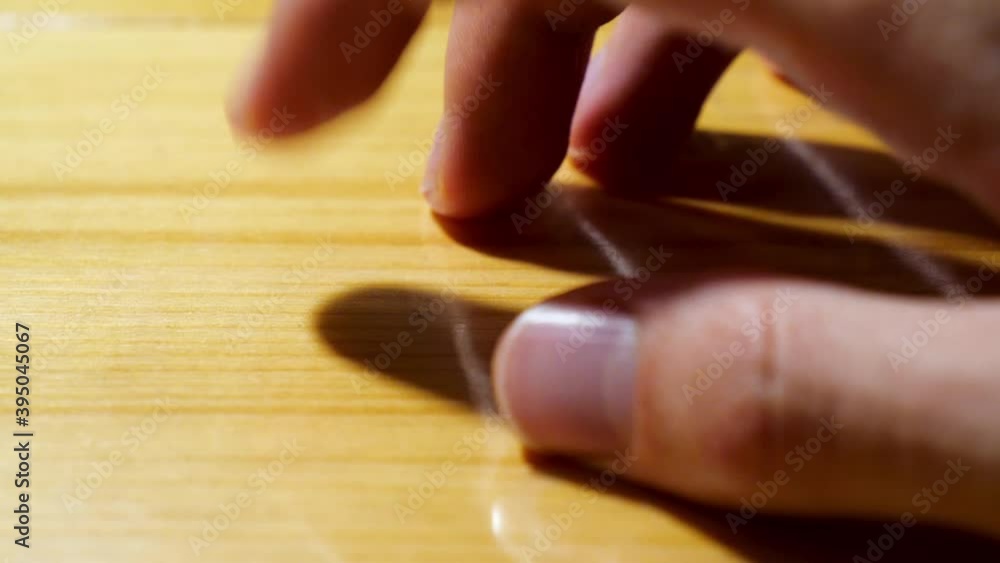 Nervous fingers tapping on the table, wooden desk surface, closeup ...