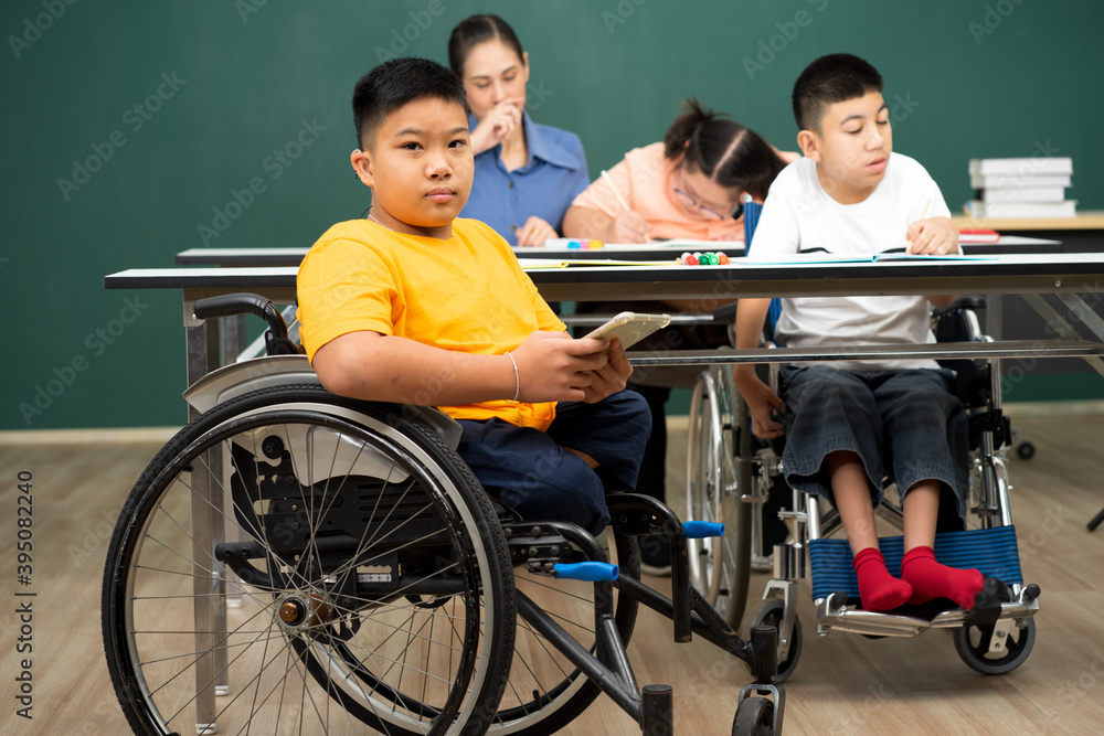 disability boy sitting on wheelchair in classroom special with teacher ...