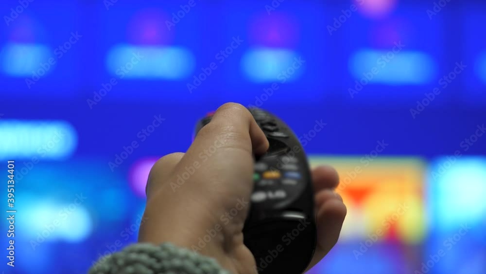 Man's hand selects internet tv channels with remote control, close-up ...