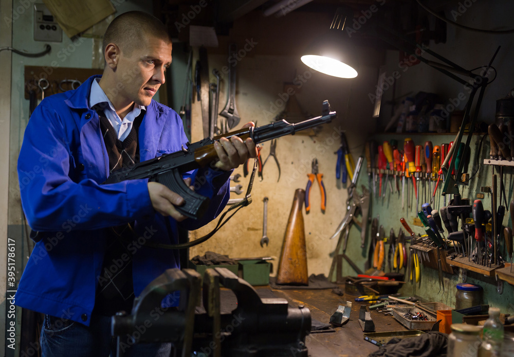 Gunsmith with Kalashnikov assault rifle in a weapons workshop Stock ...