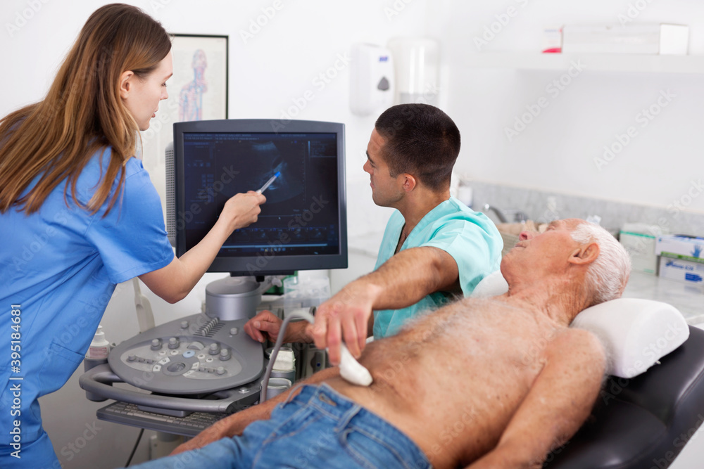 Skilled diligent efficient doctor with assistant diagnosing patient ...