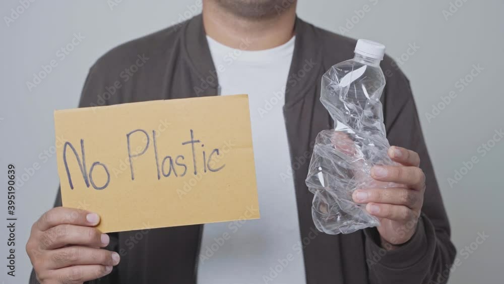 A man was raising a dented plastic bottle and a sign that reads No ...