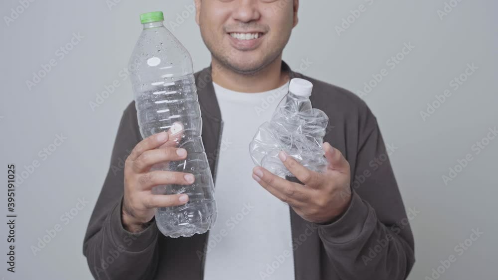 A man showing a used plastic bottle he will be recycled. World ...