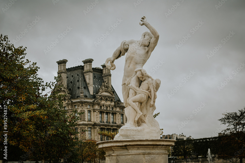 Statue of a man hiding his face from a snake in jardin des tuileries ...