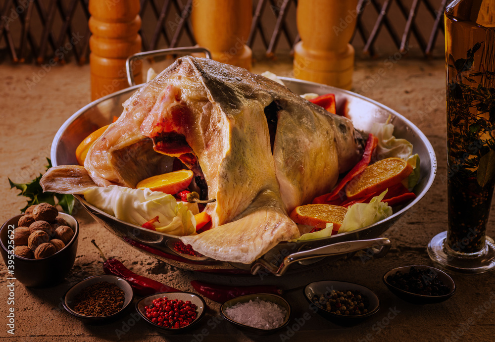 The head of a Siberian sturgeon lies in a Chinese wok on vegetables ...