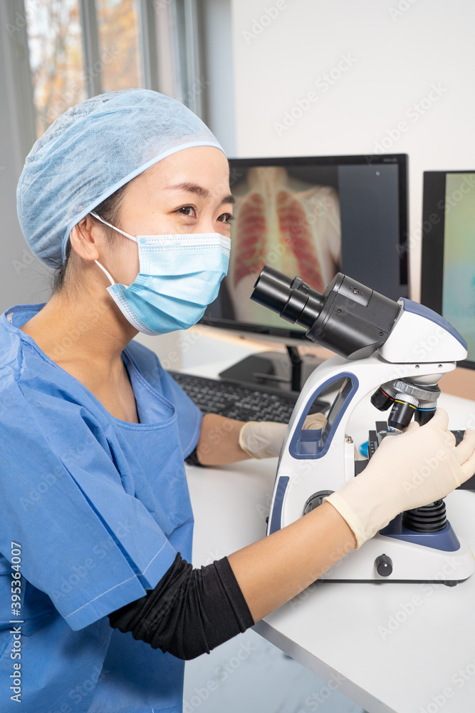 Femme médecin asiatique regarde au microscope des images médicales du ...
