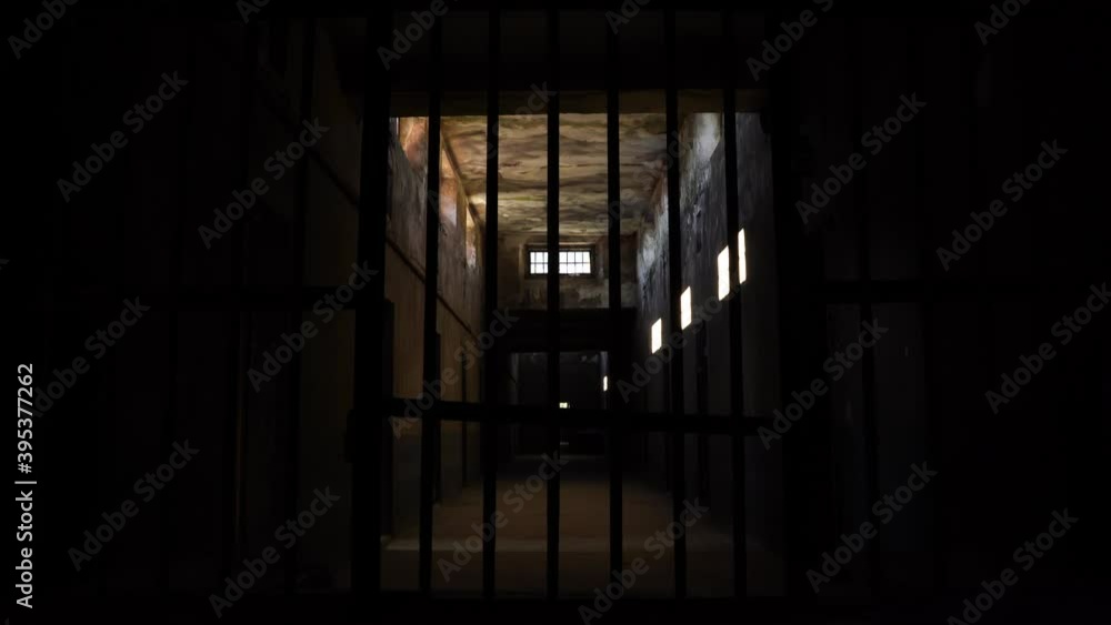 Iron gate of prison with dirty walls and small windows, dark jail ...