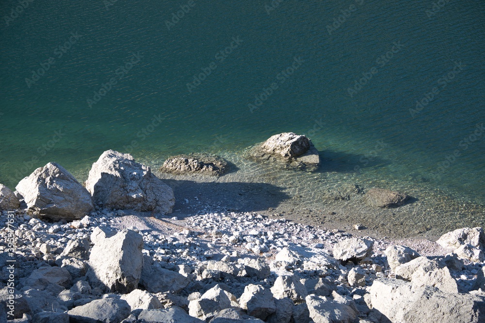 Lago di Molveno con spiaggia e scogli e sassi in Trentino Stock Photo ...