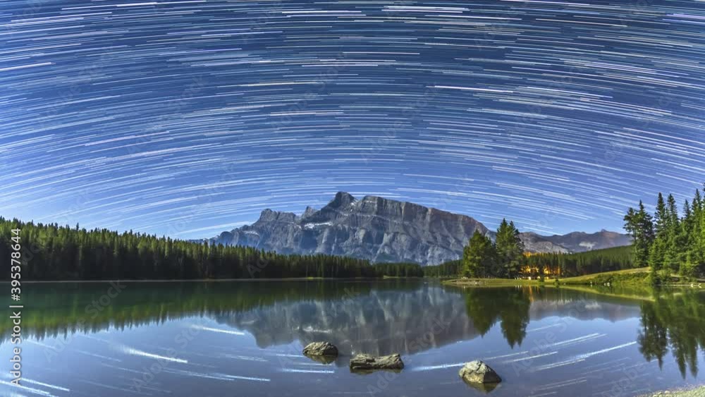 Star trails above the Mount Rundle from Two Jack Lake at night, starry ...