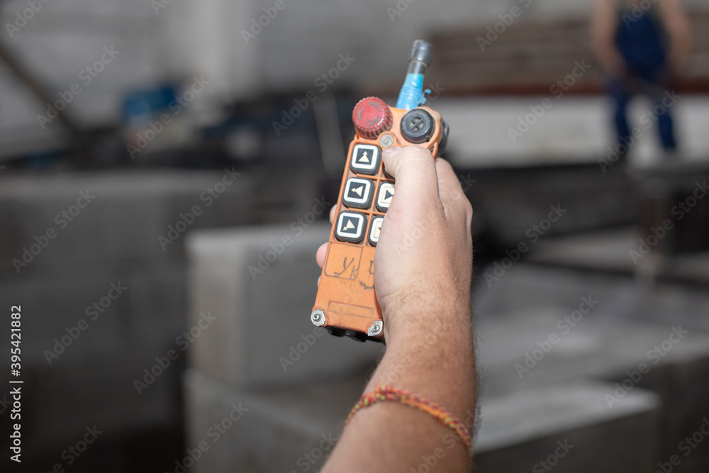 Construction worker hand operating a crane with a control panel in ...