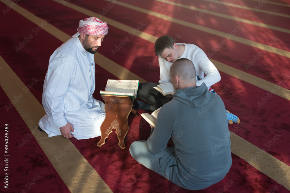 Group of muliethnic religious muslim young people praying and reading ...