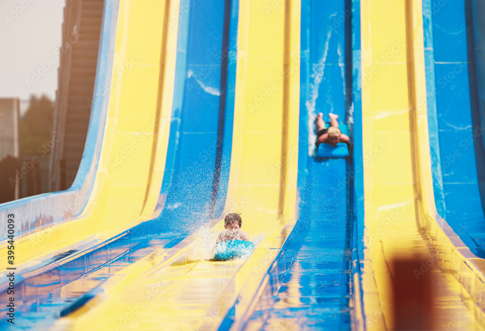 Cool people having fun on the water slide with friends and familiy in ...
