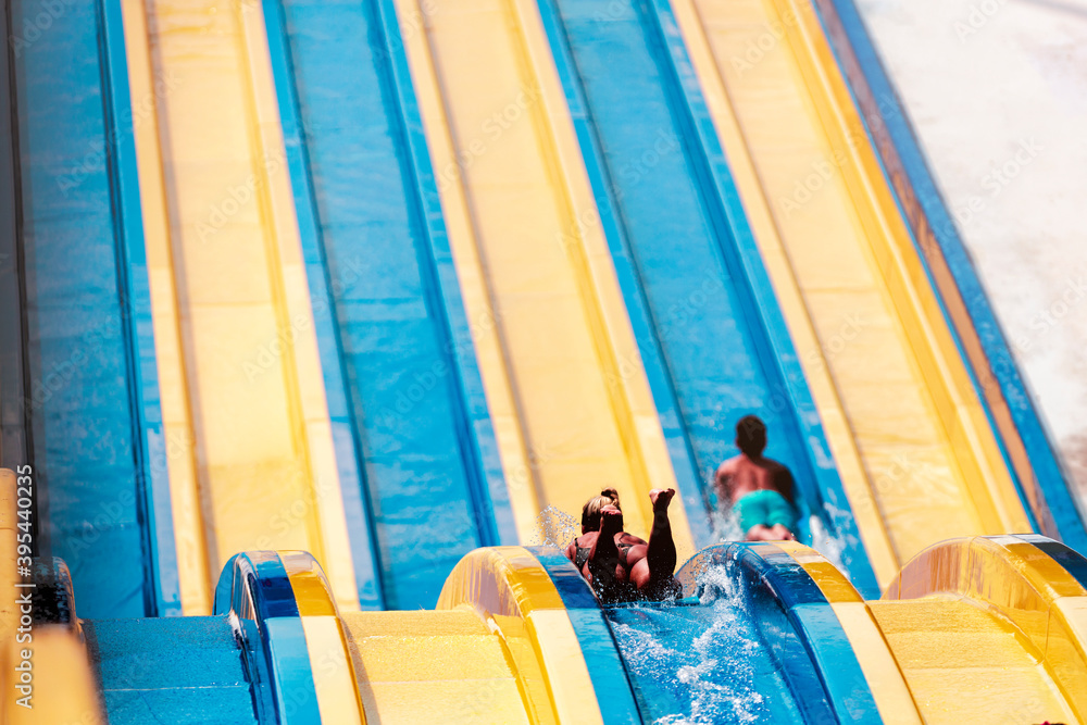 Cool people having fun on the water slide with friends and familiy in ...
