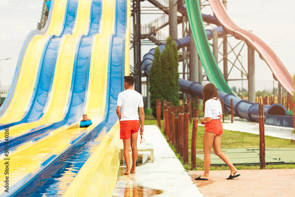 Cool people having fun on the water slide with friends and familiy in ...