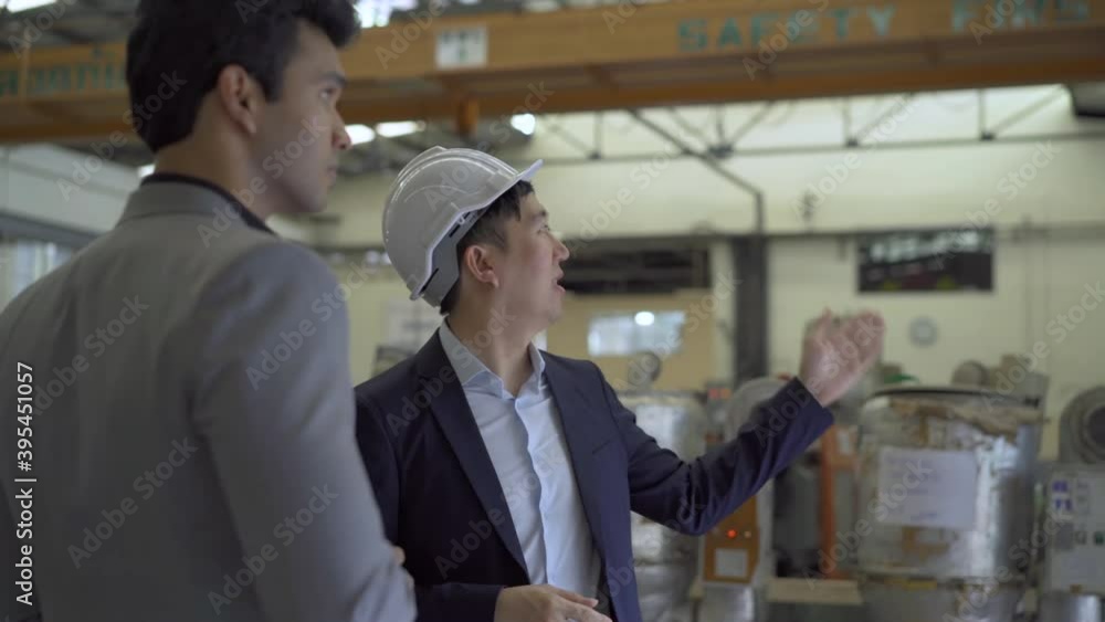 30s young Asian businessman in formal suit and hard hat showing foreign ...