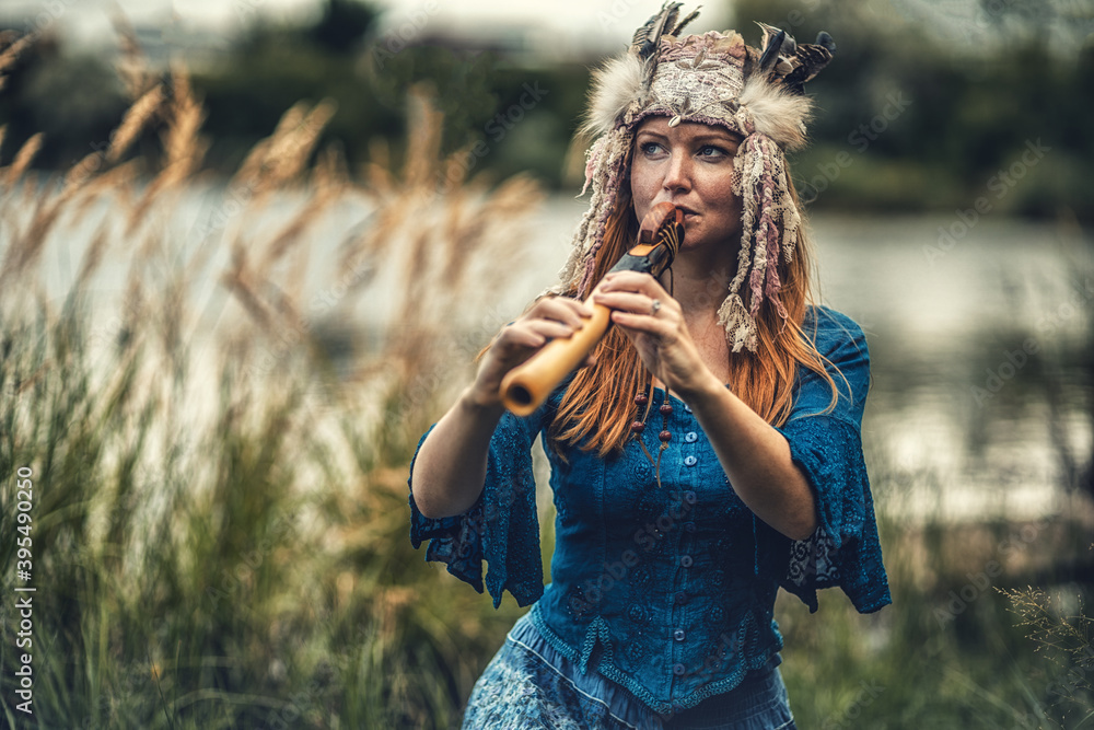 beautiful shamanic girl playing on shaman flute in the nature. Stock ...