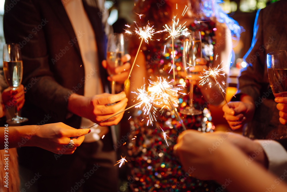 Sparkling sparklers in the hand. Group of happy people holding ...