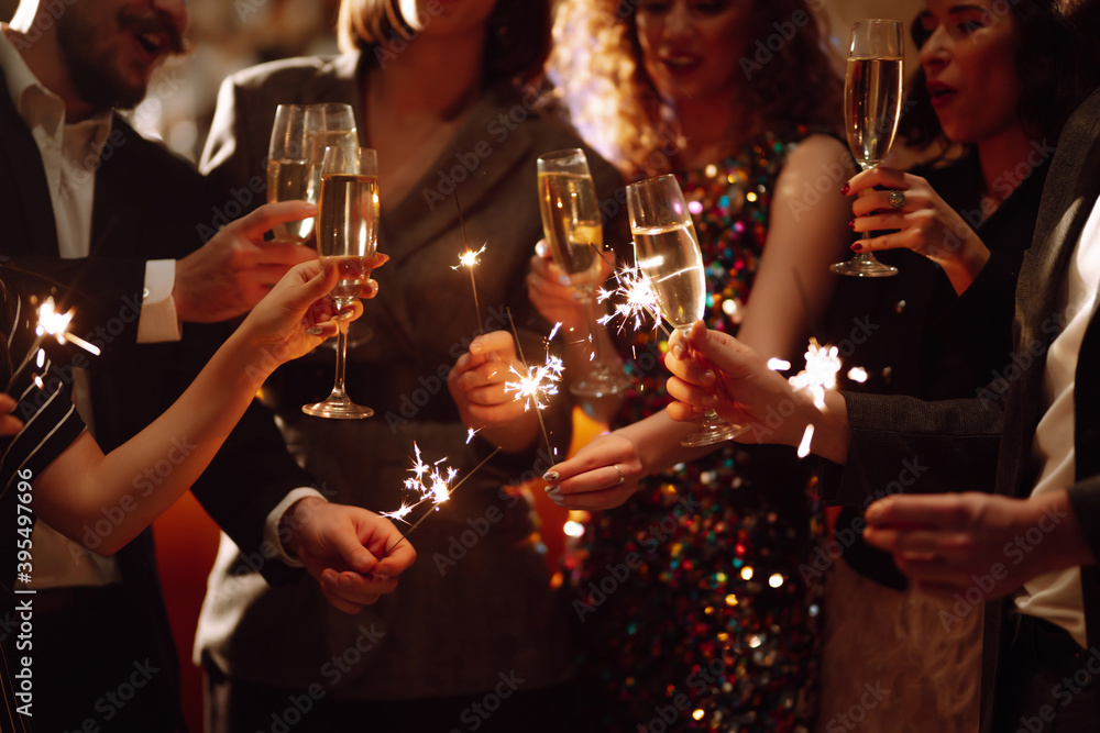 Sparkling sparklers in the hand. Group of happy people holding ...