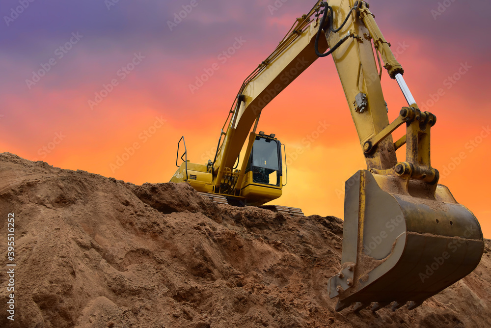 Excavator working on earthmoving at open pit mining on amazing sunset ...