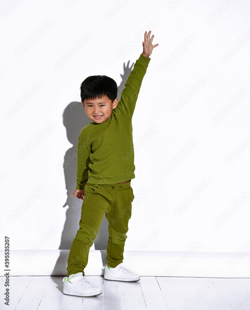 Fashion portrait of a cute little boy in a stylish green tracksuit ...
