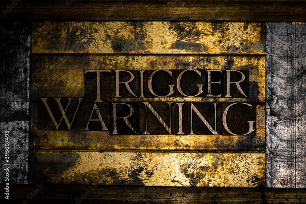 Trigger Warning text on grunge textured copper and gold background ...