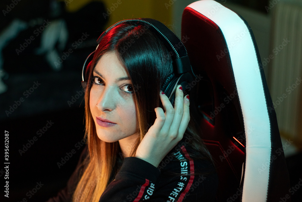 beautiful gamer girl sitting in her chair while looking at the camera ...