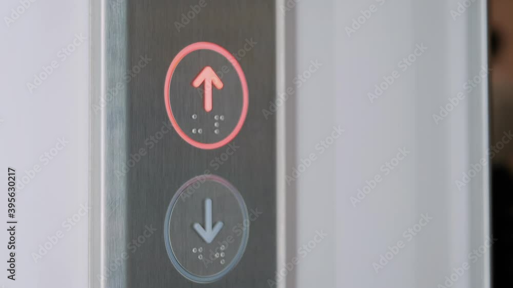 Slow motion: woman finger pressing elevator up button on lift control ...