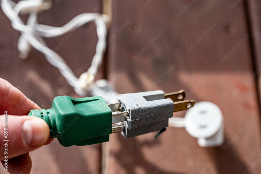 Demonstrating using a 3-prong adapter to connect two power cords Stock ...