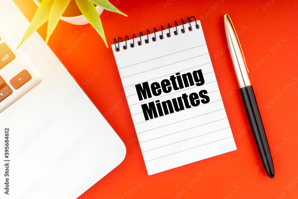 MEETING MINUTES text with notepad, laptop, fountain pen and decorative ...