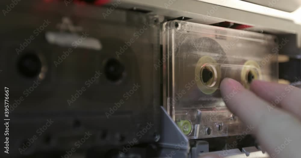 Audio cassette in the tape recorder playing and rotates. Vintage audio ...