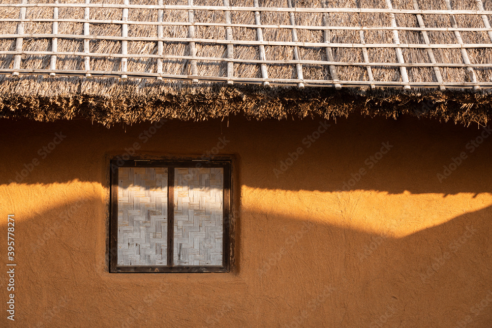 vintage window on clay wall with old grass roof Stock Photo | Adobe Stock