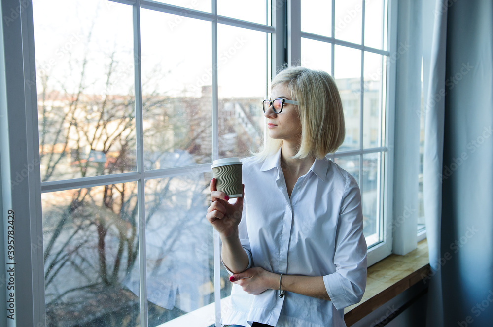 Beautiful young woman drinking tea at home. Looking away. Smiling girl ...