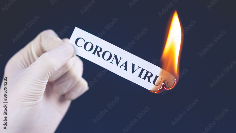 Paper with the text Coronavirus is burning on a black background. The ...