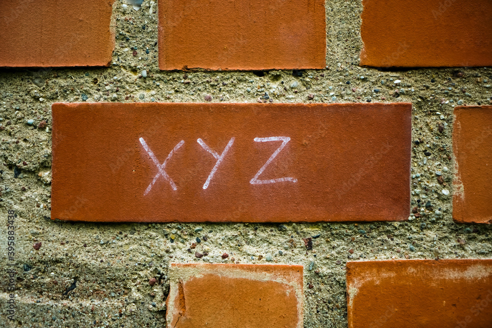 xyz inscription painted on red brick wall background for design and ...