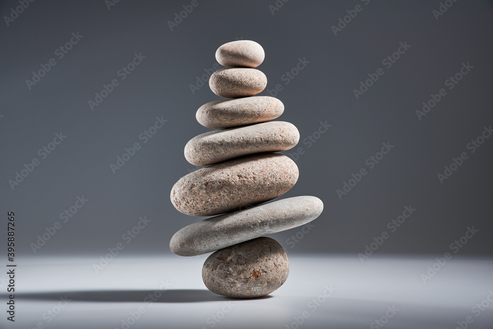 Balancing pyramid of sea pebbles on a gray background, the concept of ...