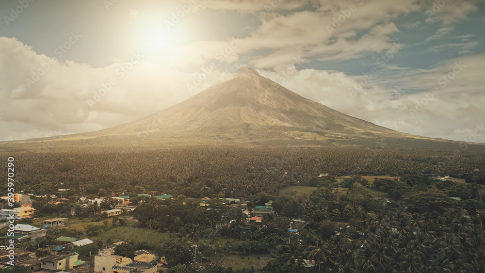 Aerial volcano erupt at sunlight closeup. Sun cityscape of rural town ...